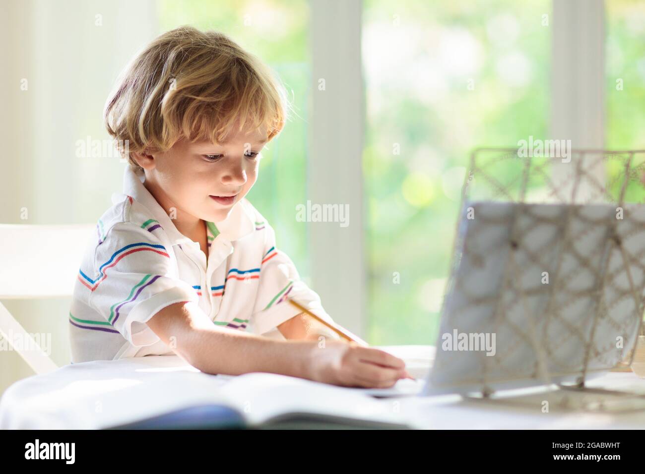 Child studying from home doing homework. Online remote learning. School ...