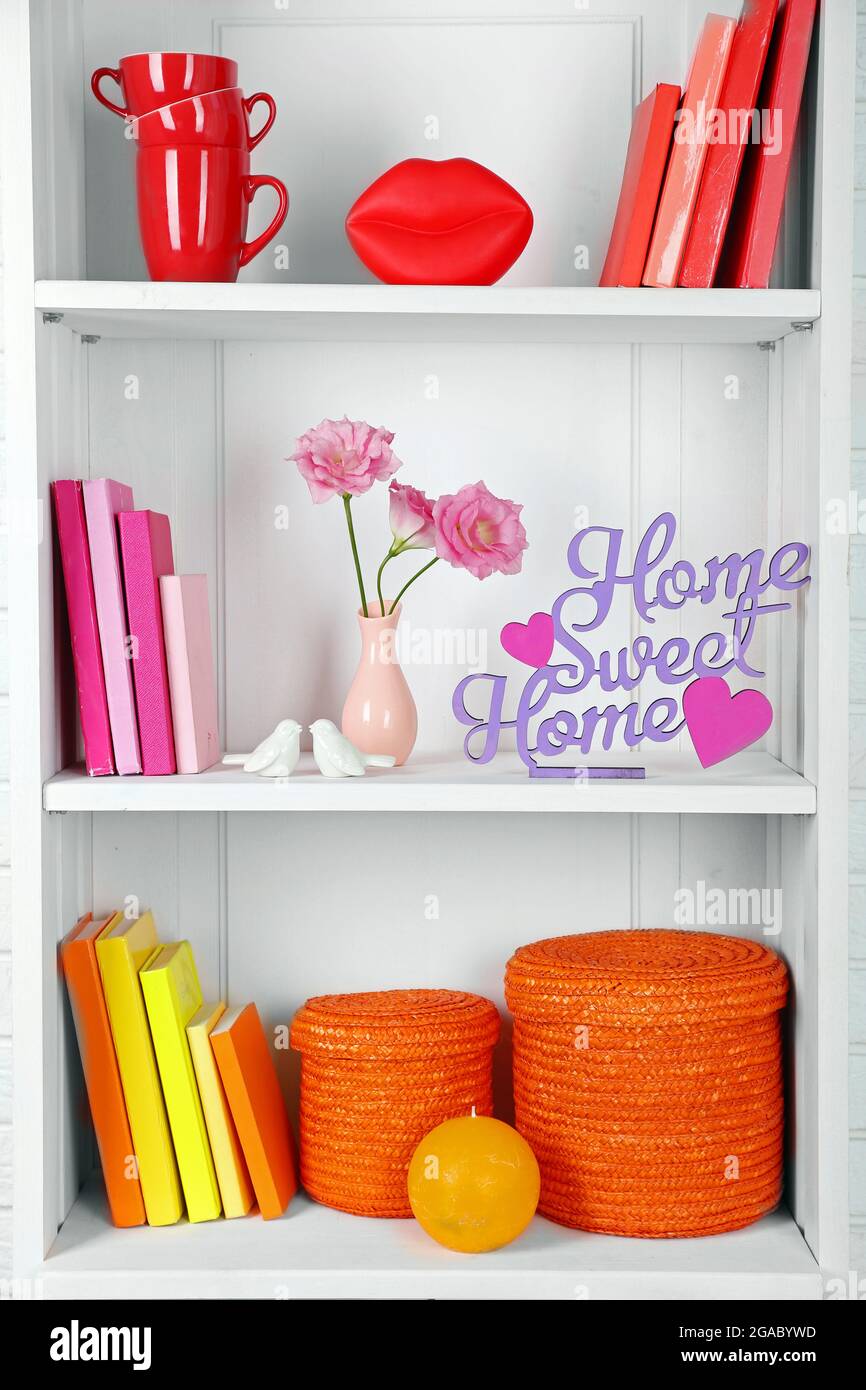 Books and decor on shelves in cupboard Stock Photo - Alamy