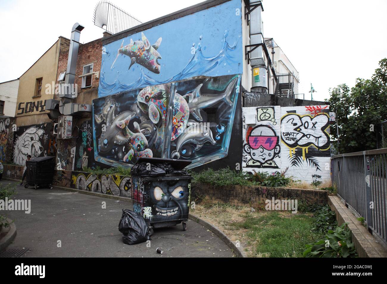 Graffiti on a building exterior and a garbage can in Shoreditch, London ...