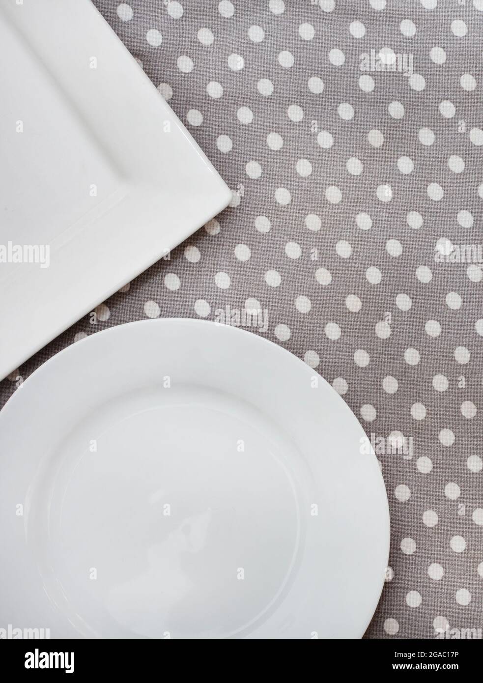 plates on polka dot table cloth with copy space Stock Photo - Alamy