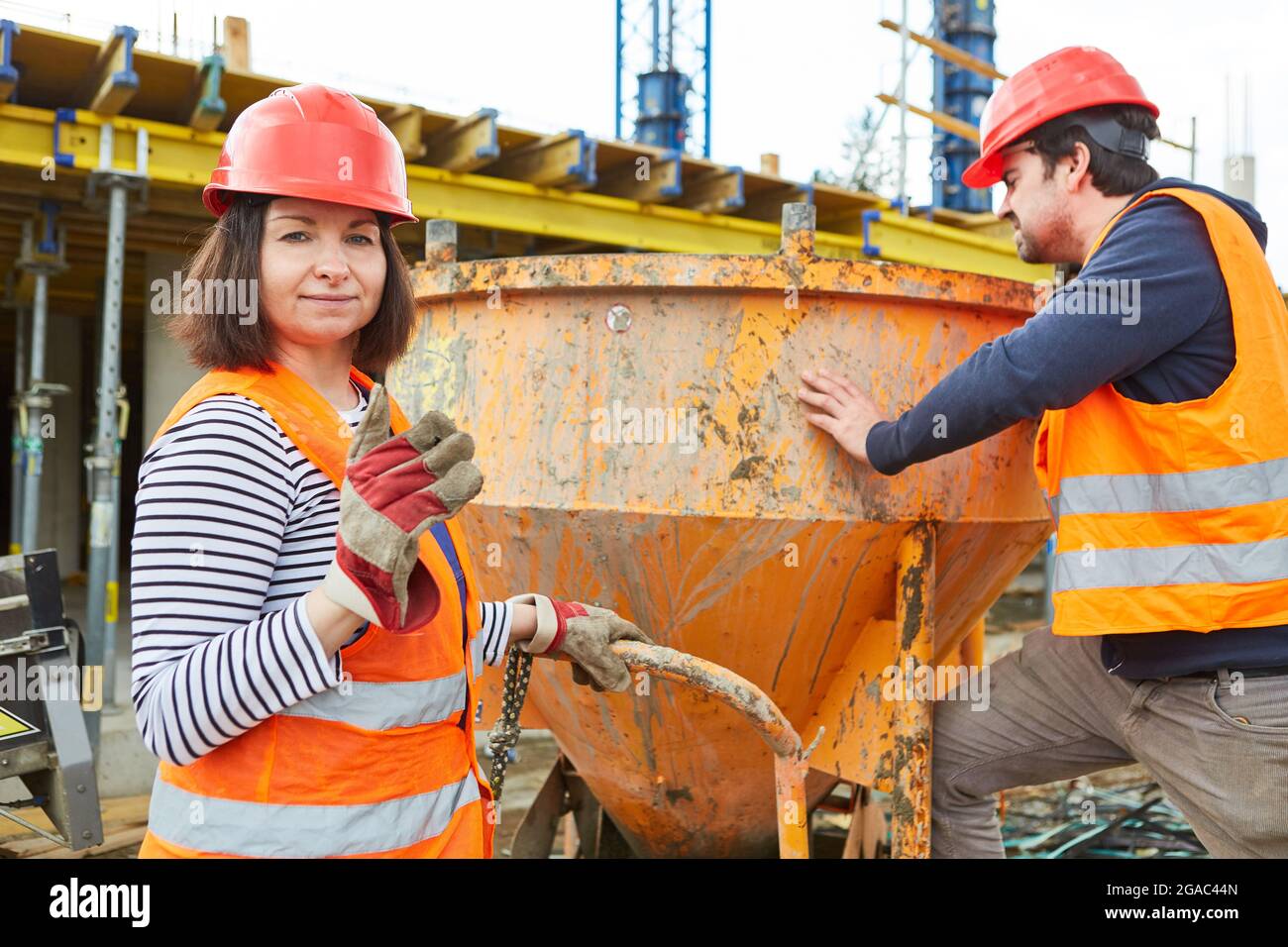 Construction workers team works on cement mixer on the new building ...