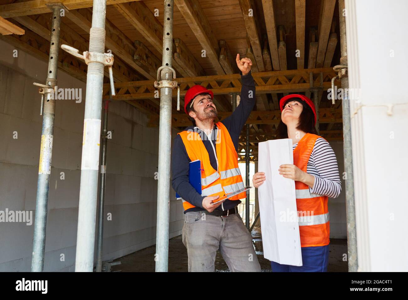 Carpenter and architect on a construction site are discussing the ...