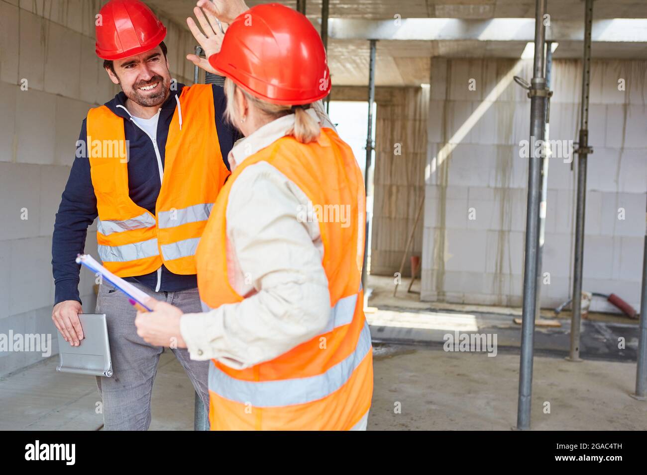 Construction workers or craftsmen at the high five as a greeting with ...