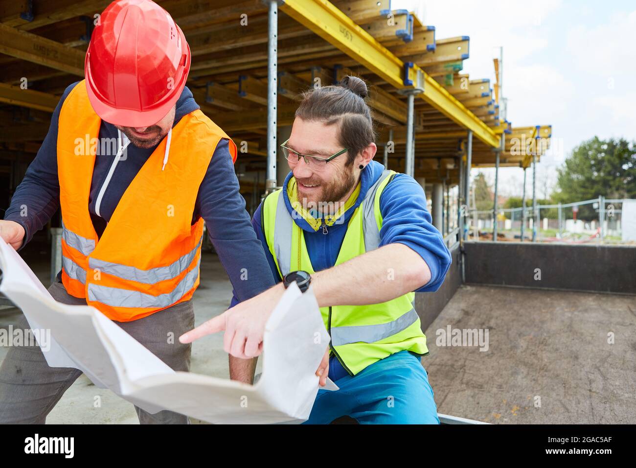 Foreman and architect with construction drawing for house construction ...