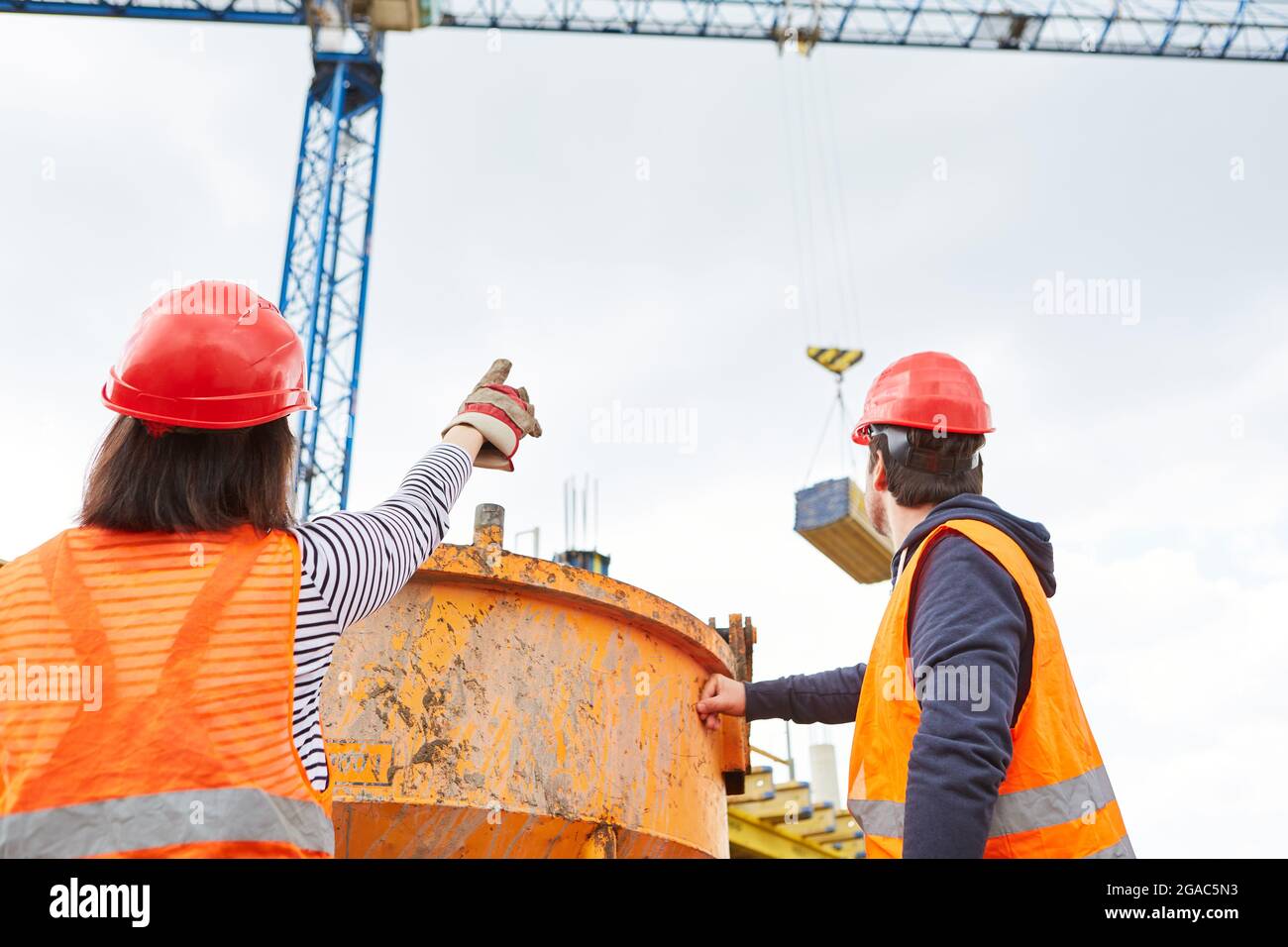 Foreman at the cement mixer gives instructions for the crane on the ...