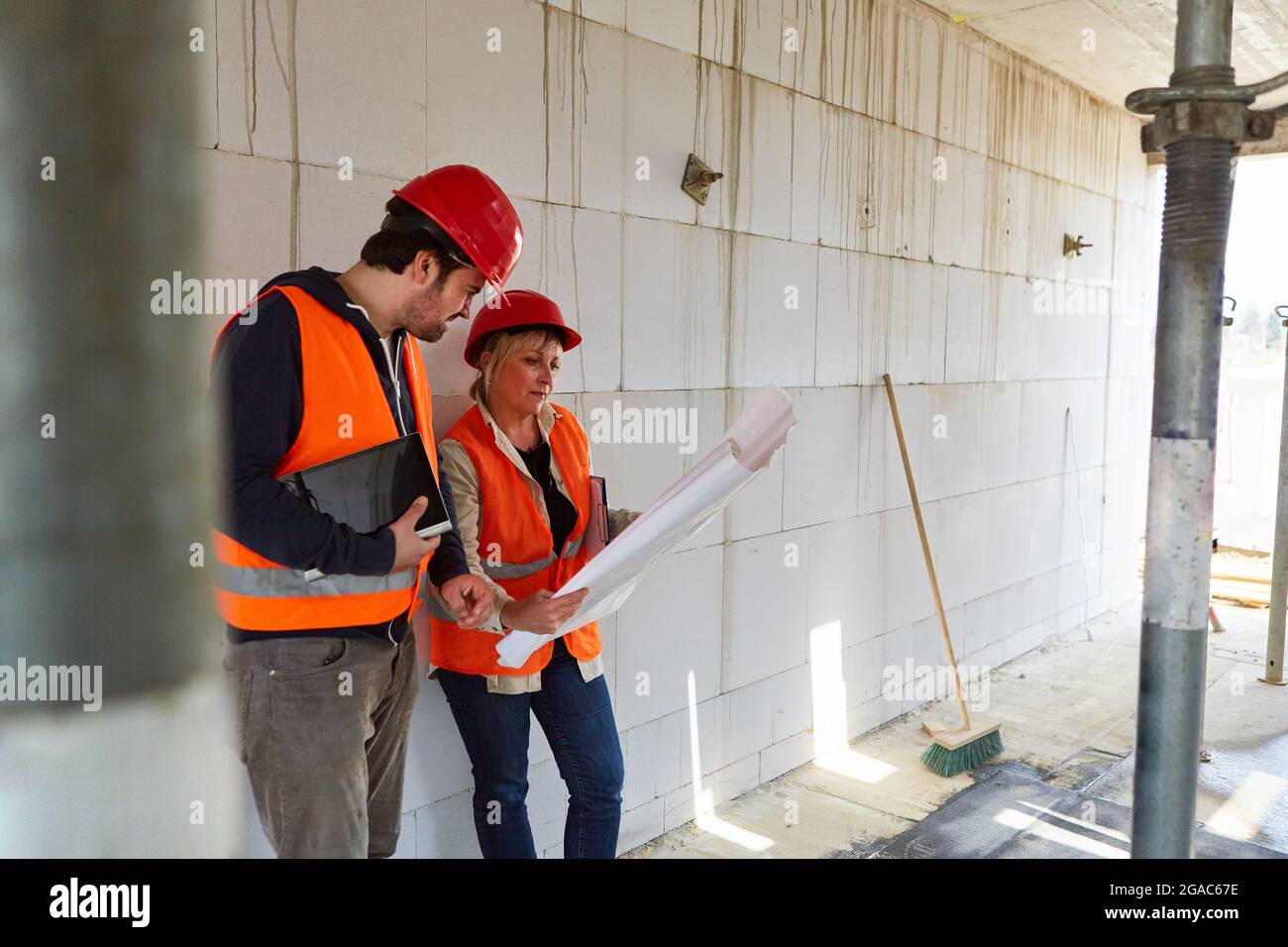 Architects team with construction drawing on the construction site in ...