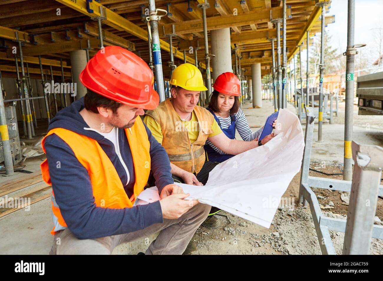 Team of craftsmen and architects with building drawings when building a ...