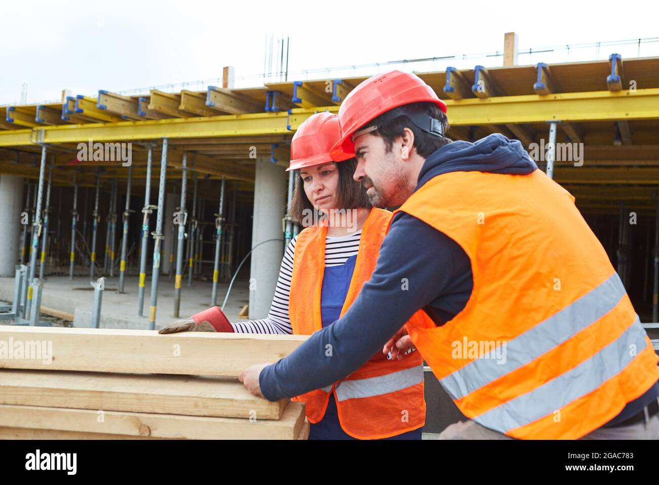 Carpenter and colleague loading and transporting timber on the ...