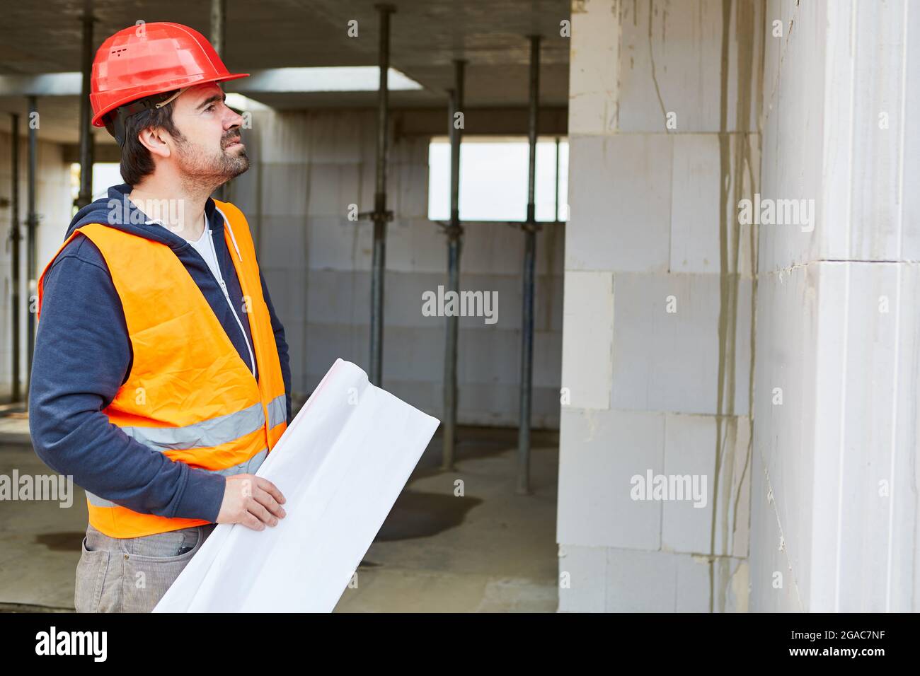 Craftsmen or building appraisers with construction drawings inspect ...