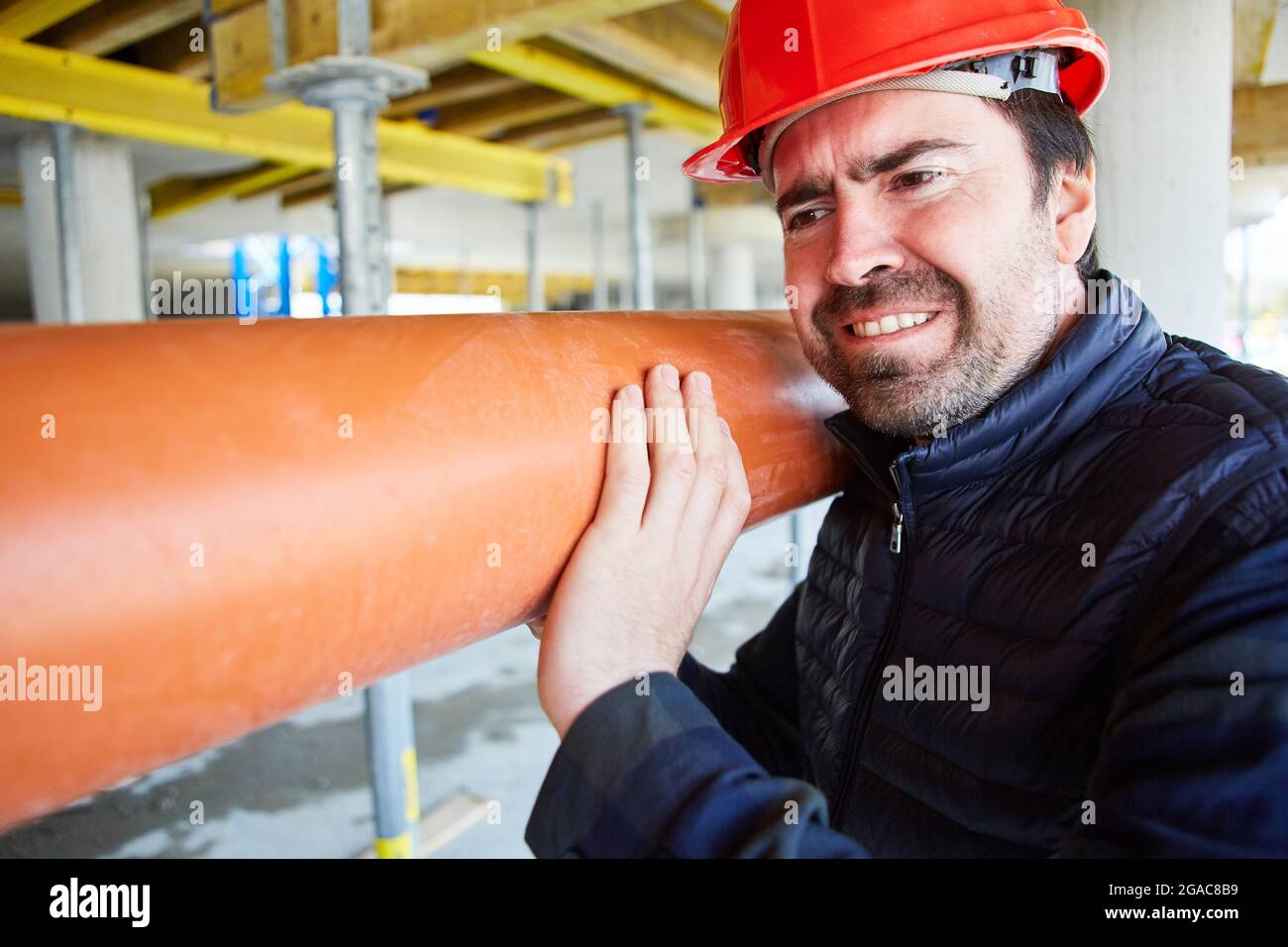 Craftsman on the construction site in the shell transports a plastic ...