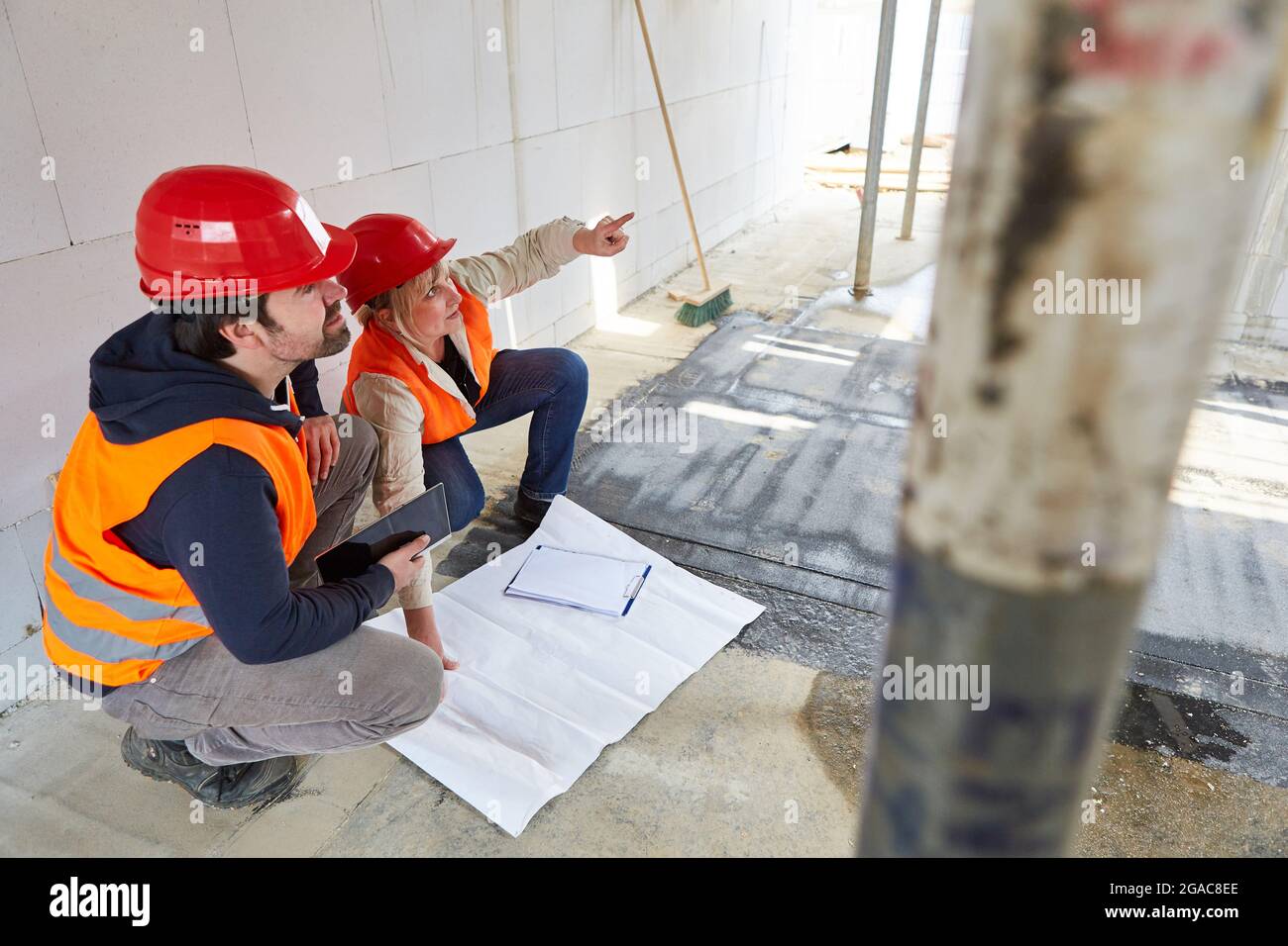 Architect team with floor plan on the construction site in the shell ...
