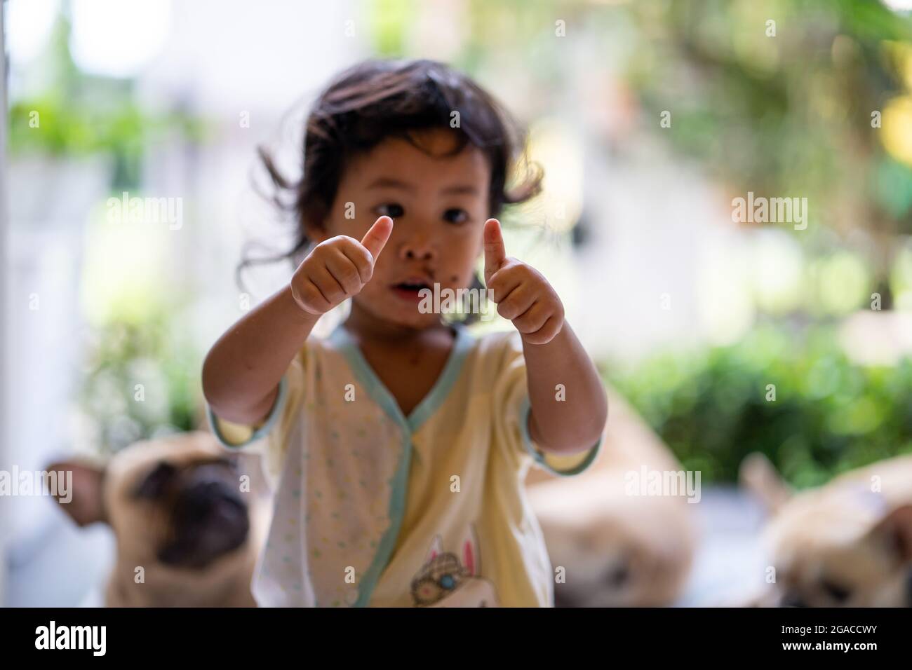 Adorable Thai baby girl showing thumbs up Stock Photo - Alamy