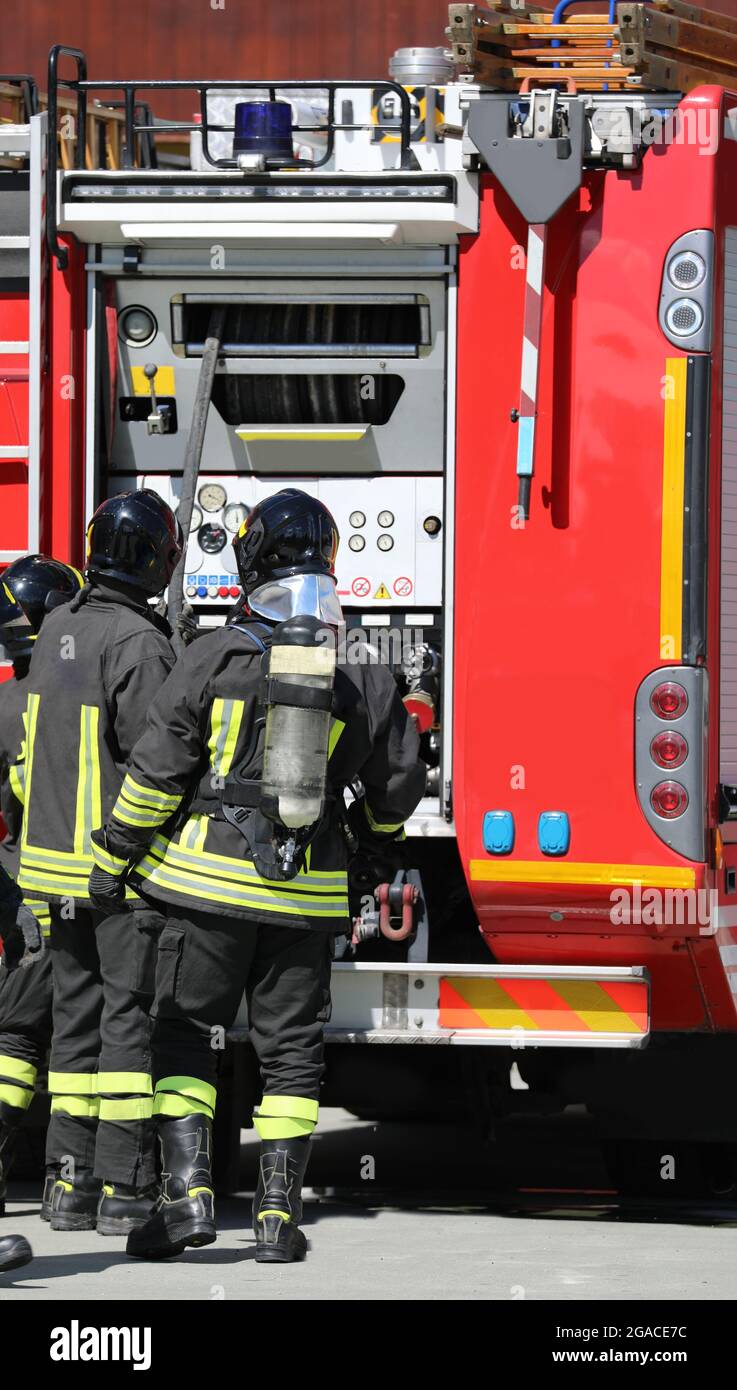 Teamwork of firefighters and the firetruck during the emergency Stock ...