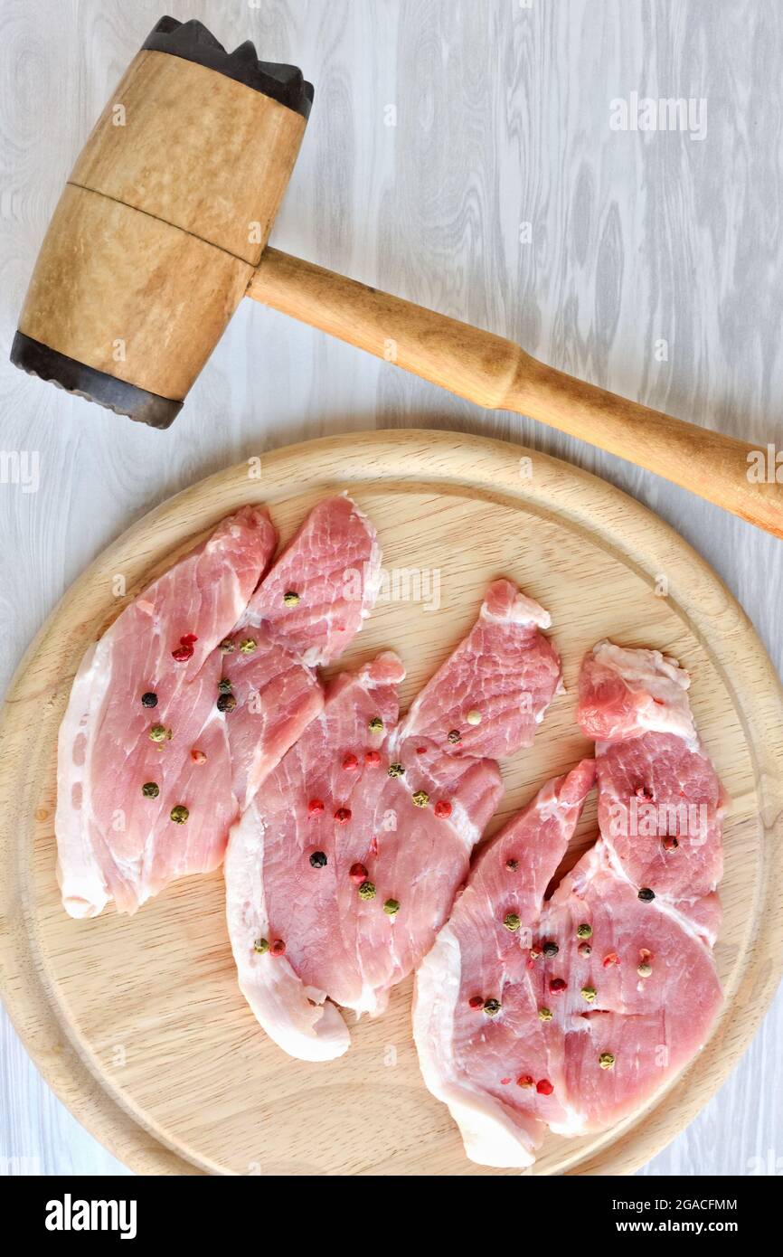 spiced raw pork chop and wooden hammer for beating meat Stock Photo - Alamy