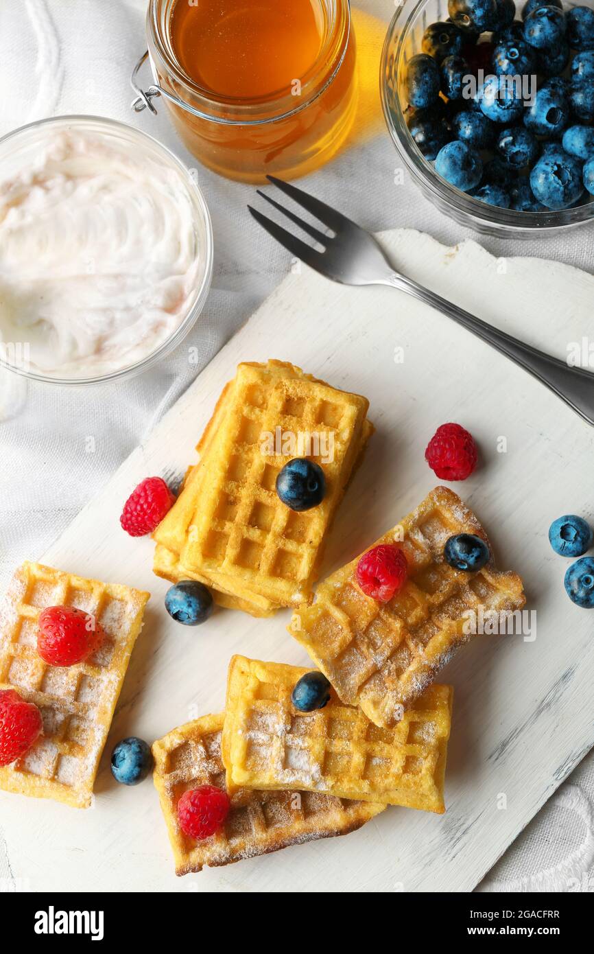 Sweet homemade waffles on tray, on light background Stock Photo - Alamy