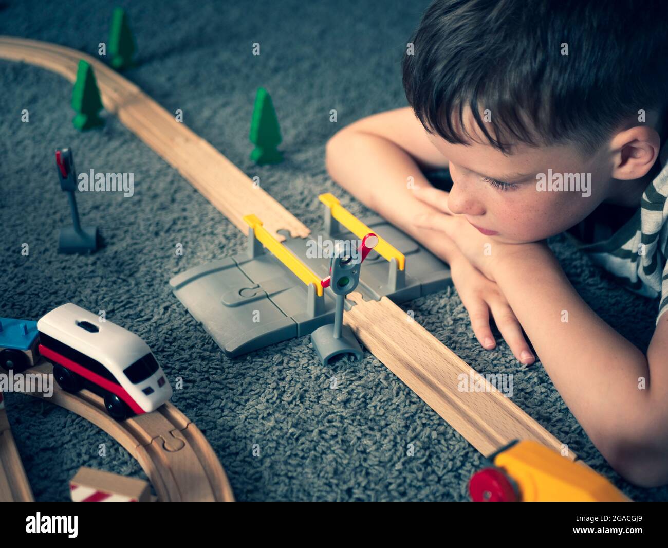 Boy is watching at the running toy train. Wooden toy railway and kid's ...