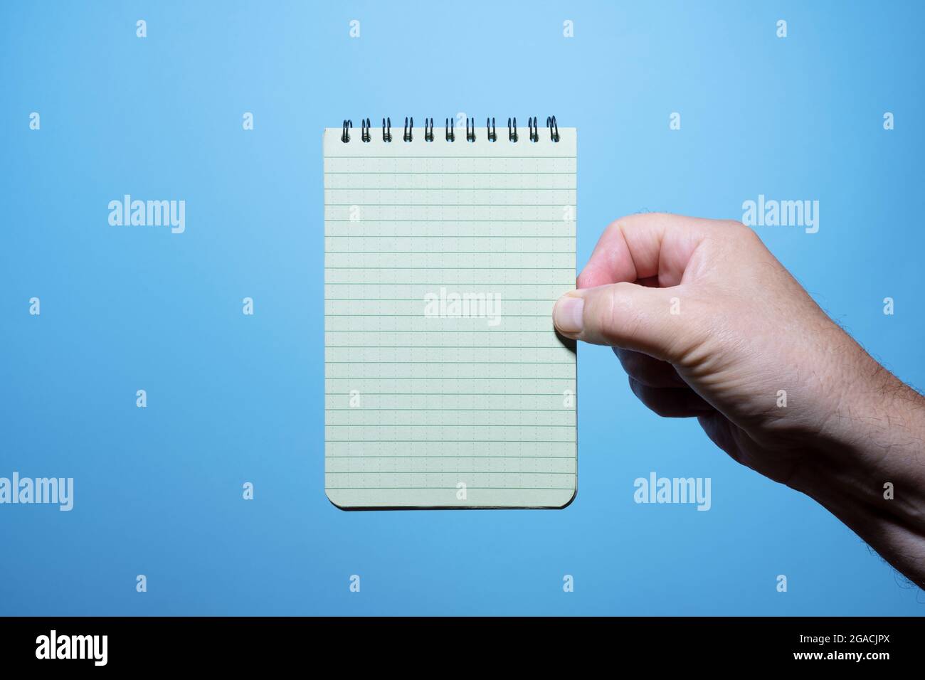 a notepad in a man's hand with the blue background Stock Photo - Alamy