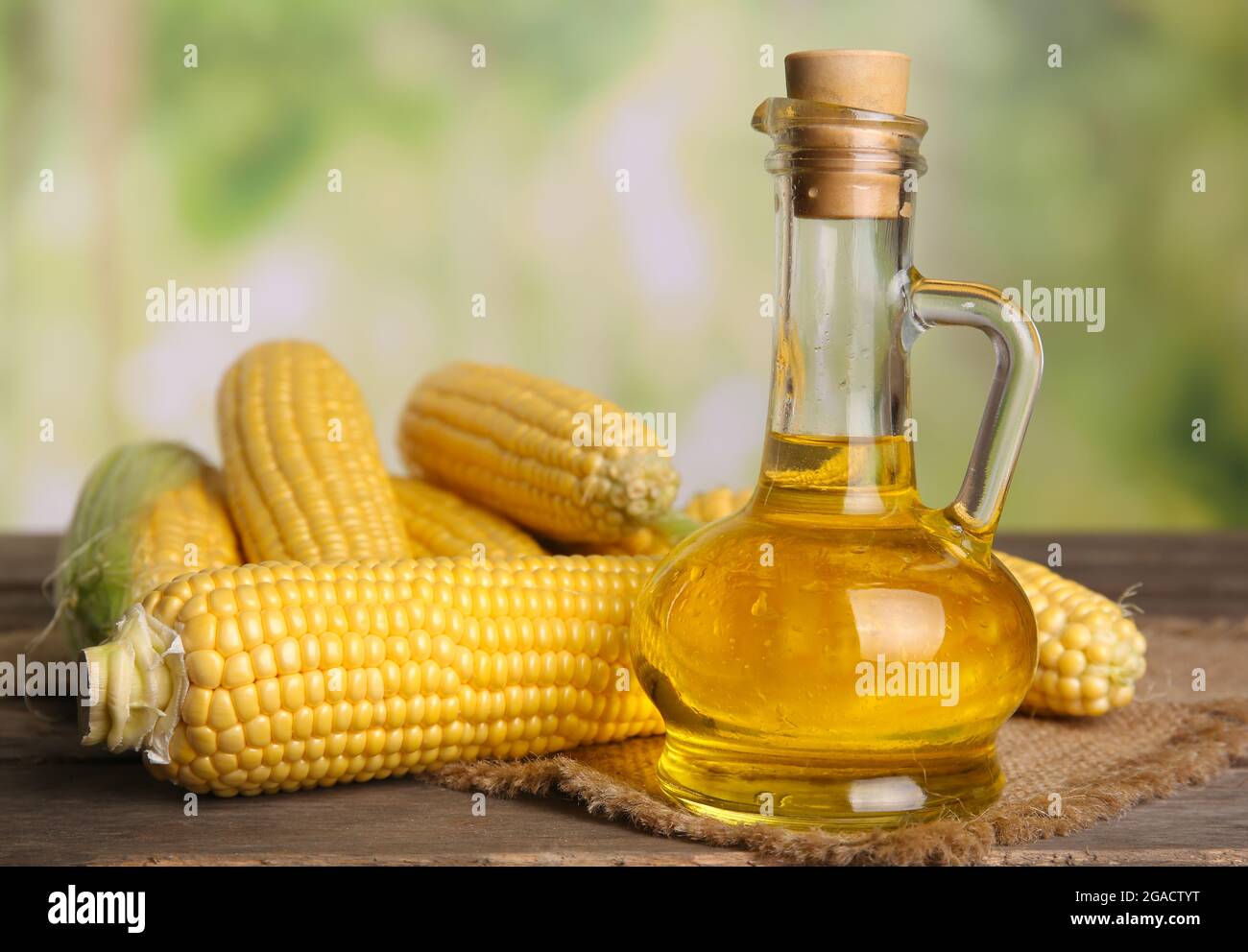 Bottle of oil with fresh corn on bright background Stock Photo - Alamy