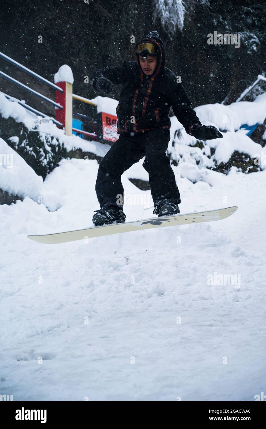 MANALI, INDIA - Jan 20, 2020: A vertical shot of a man jumping with a ...