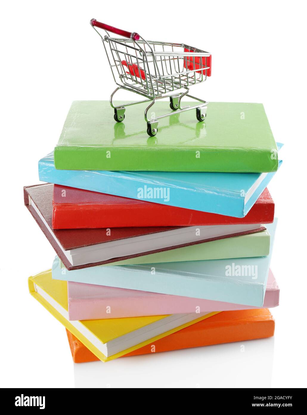Stack of colorful books with small shopping cart isolated on white ...