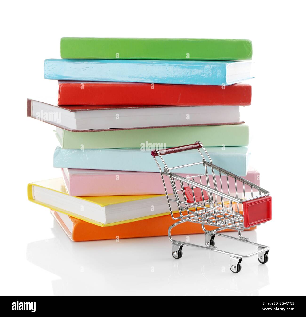 Stack of colorful books with small shopping cart isolated on white ...
