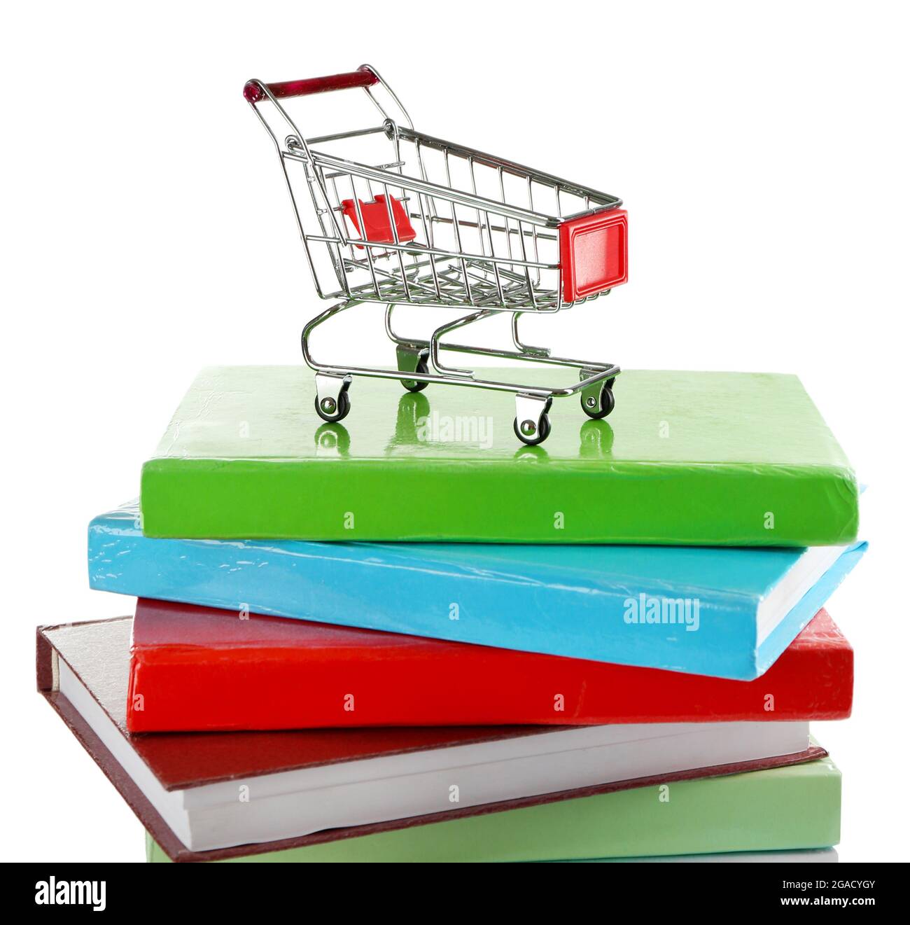 Stack of colorful books with small shopping cart isolated on white ...