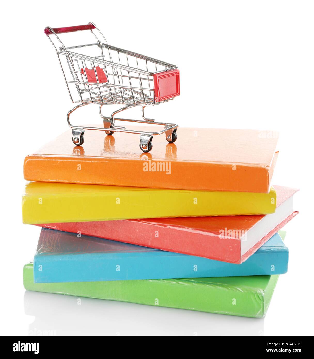 Stack of colorful books with small shopping cart isolated on white ...