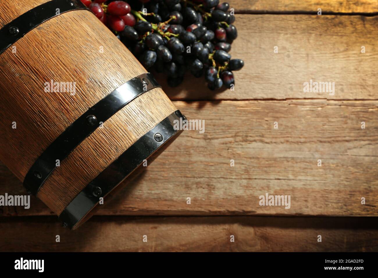 Old wine barrel and grape on wooden background Stock Photo - Alamy