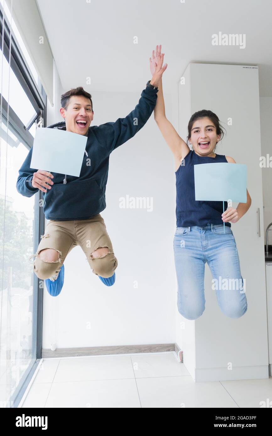 Young people jumping for joy with posters Stock Photo - Alamy