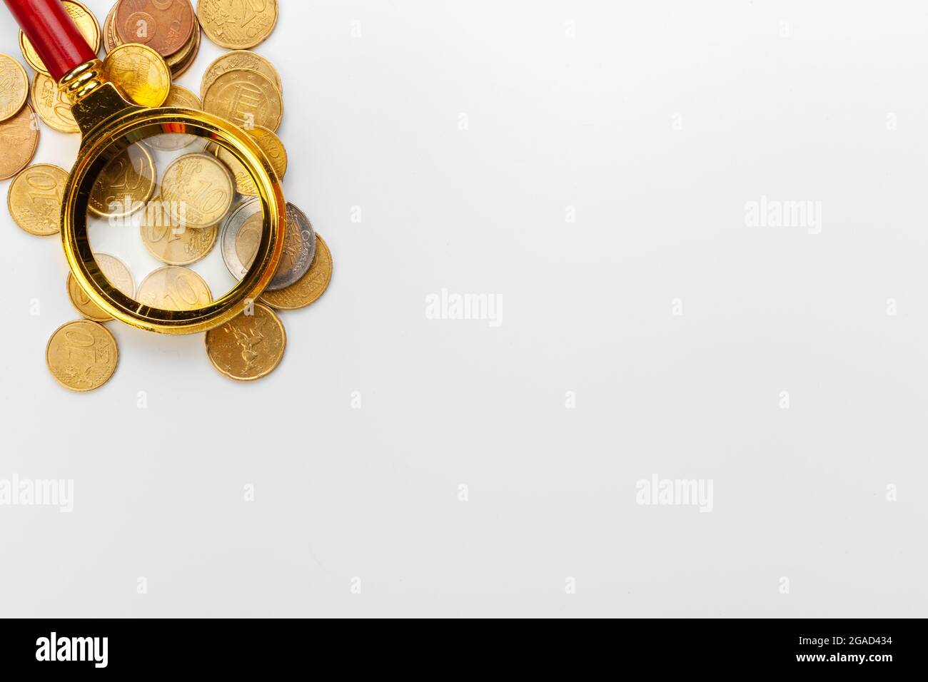 Magnifier and coins Stock Photo - Alamy