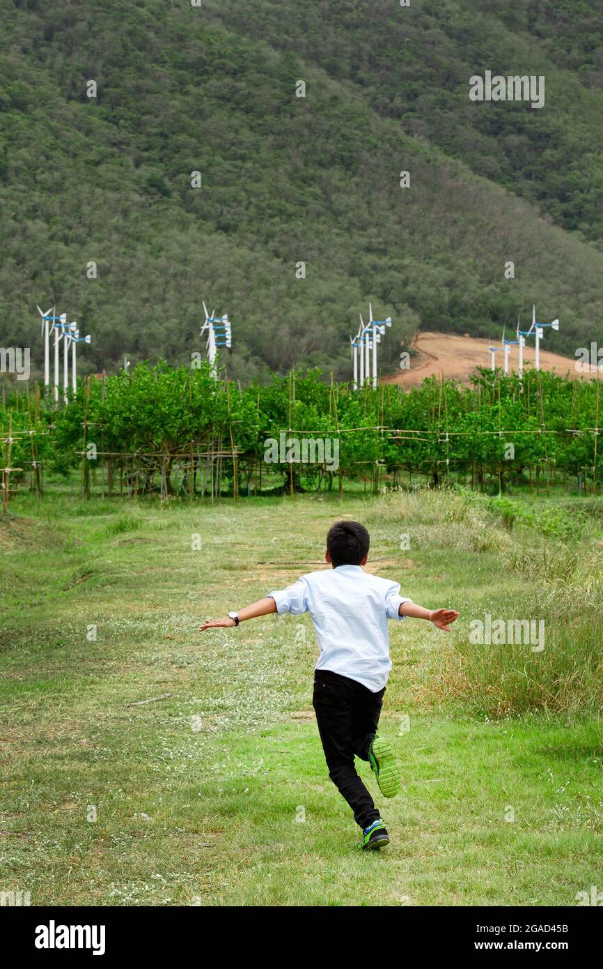 Boy running to group of wind turbines Stock Photo - Alamy