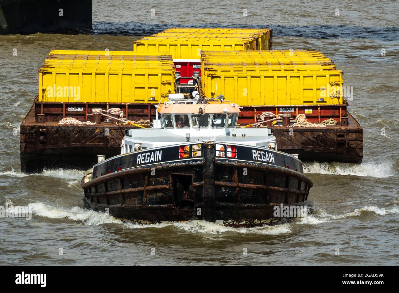 Inland Supply Vessel Regain towing yellow waste containers up river on ...