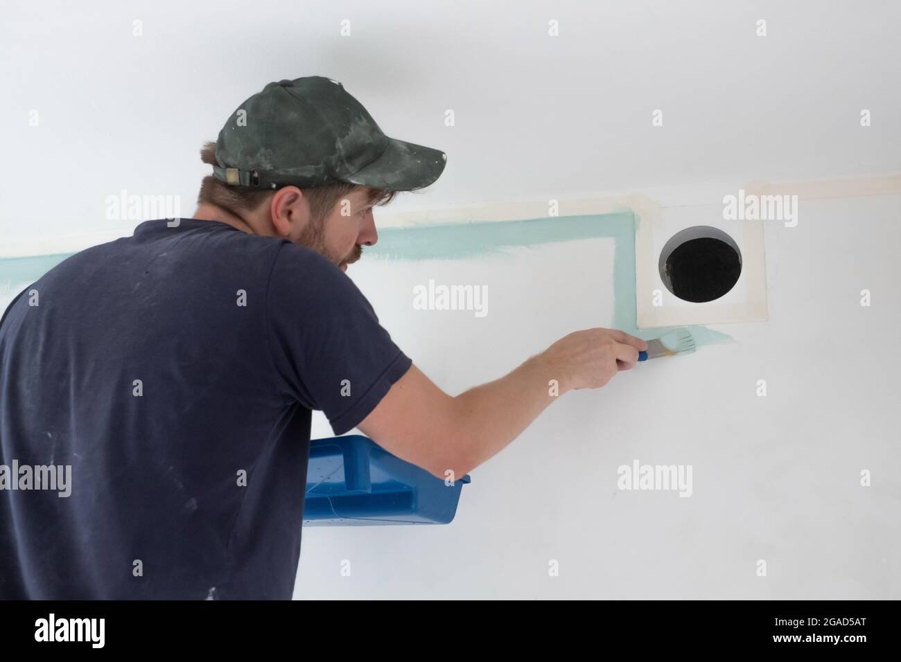 Worker painting walls with a brush during flat renovation Stock Photo ...