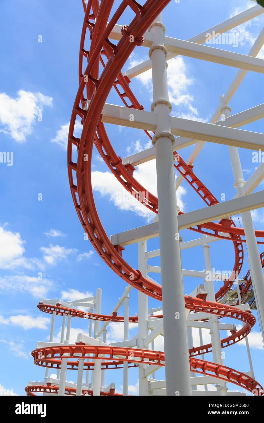 Red roller coaster line with blue sky in background Stock Photo - Alamy