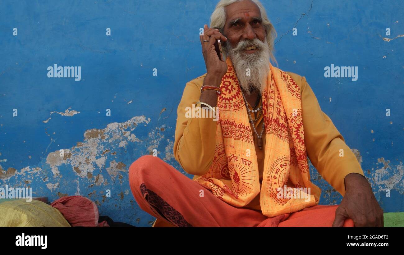 Closeup of an old Indian monk talking on the phone Stock Photo - Alamy