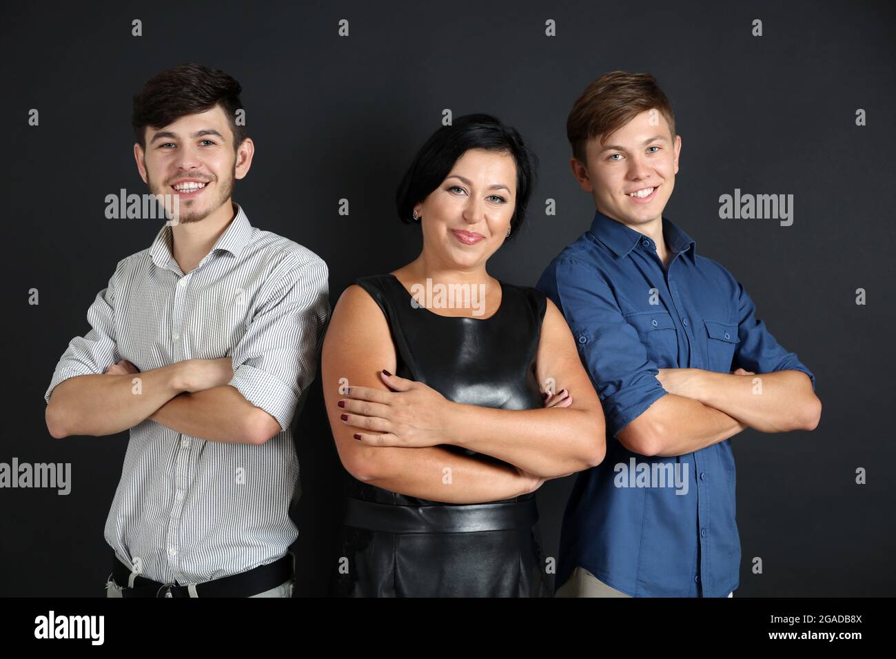Portrait of mother and her sons on dark background Stock Photo - Alamy