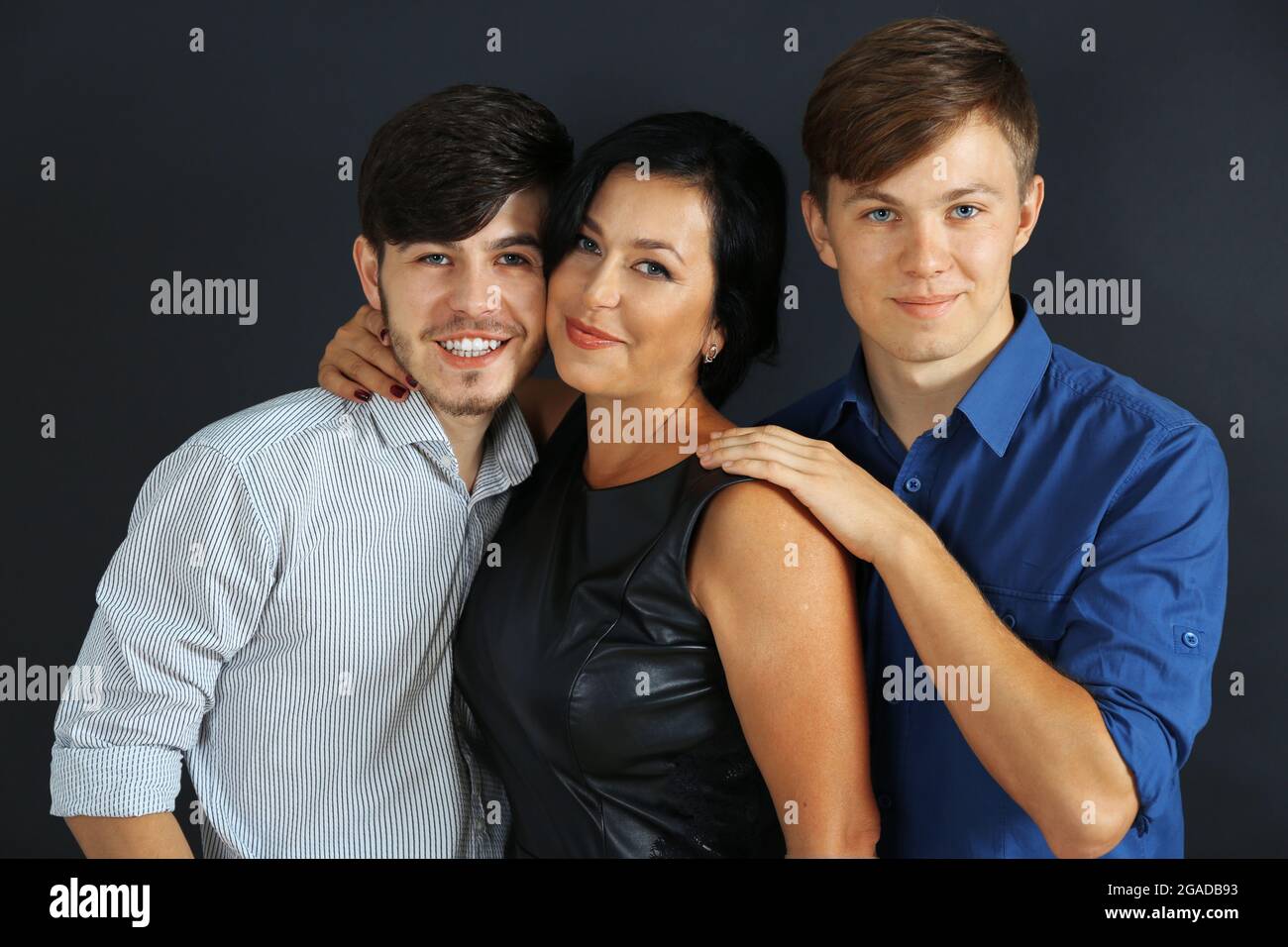 Portrait of mother and her sons on dark background Stock Photo - Alamy