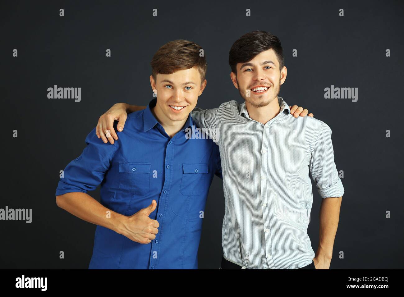 Two brothers on dark background Stock Photo - Alamy