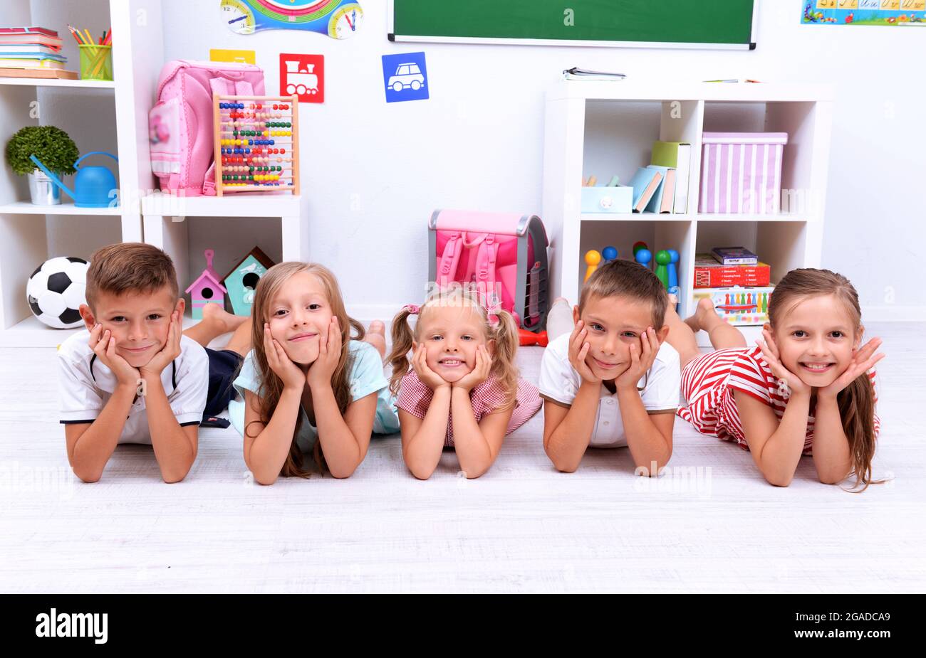 Row of children on floor in classroom Stock Photo - Alamy