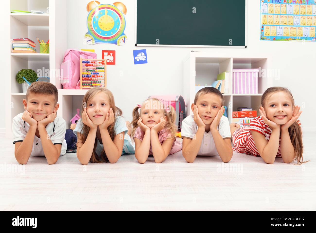 Row of children on floor in classroom Stock Photo - Alamy