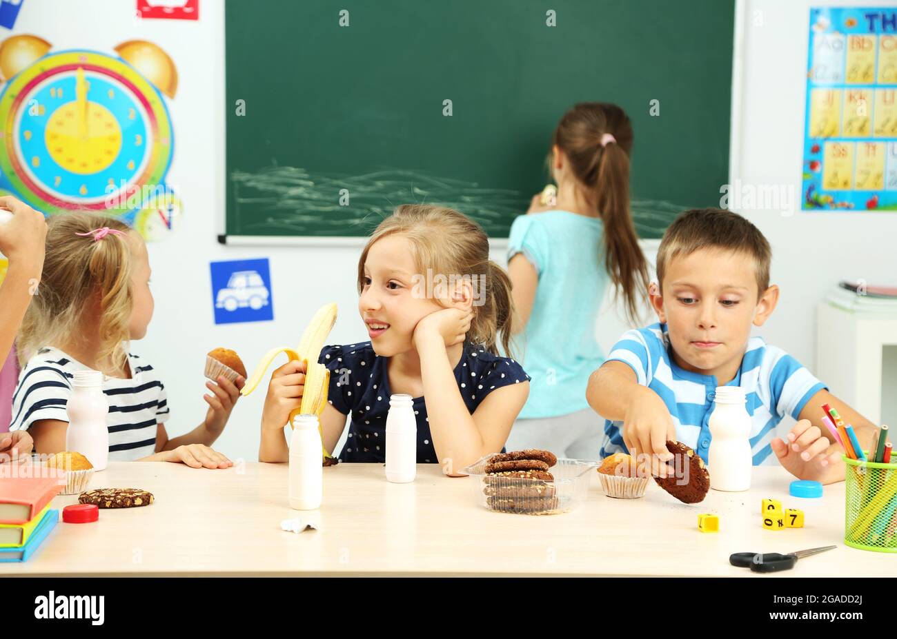 Cute children at lunch time in classroom Stock Photo - Alamy