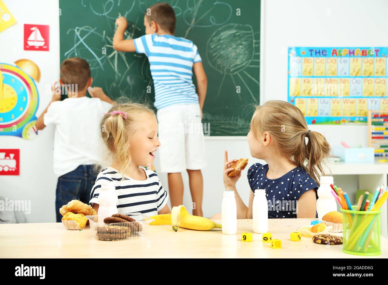 Cute children at lunch time in classroom Stock Photo - Alamy