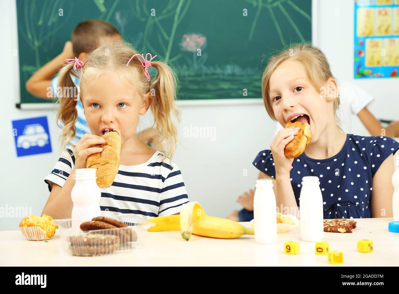 Cute children at lunch time in classroom Stock Photo - Alamy