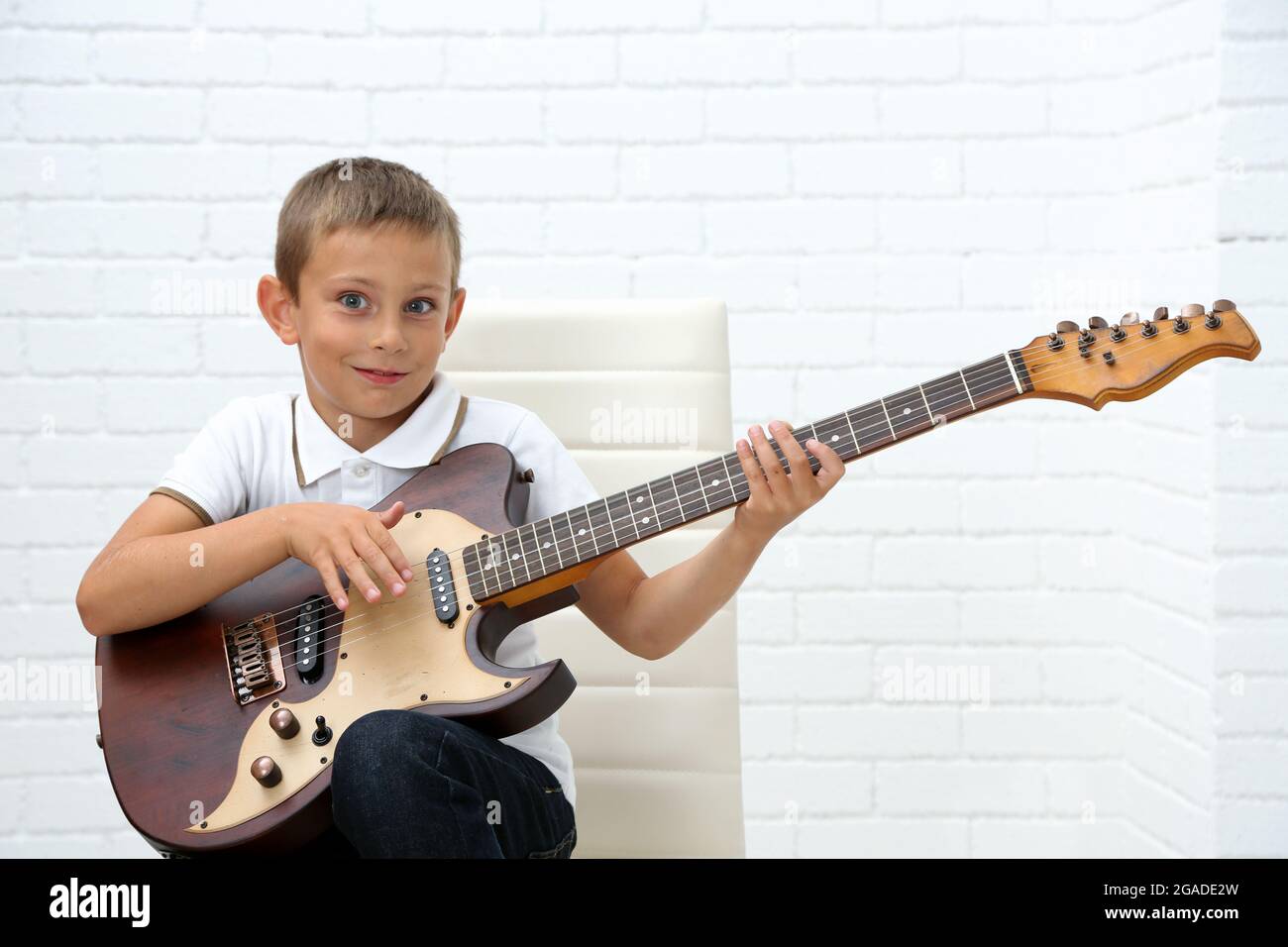 Little boy playing guitar on light background Stock Photo - Alamy