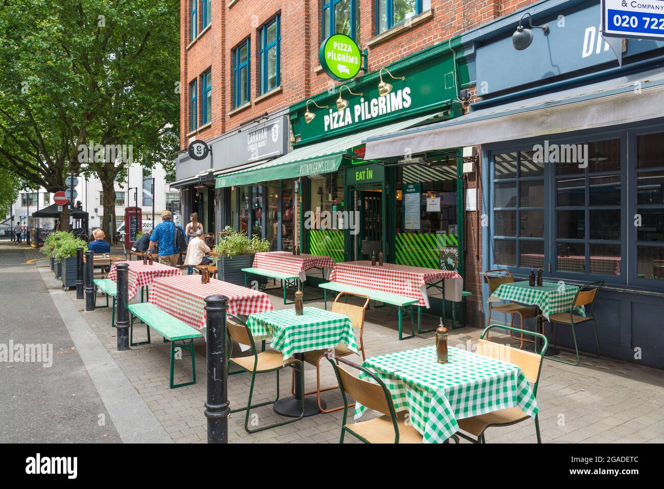 Pavement tables set up outside Pizza Pilgrims and Caravan restaurants ...