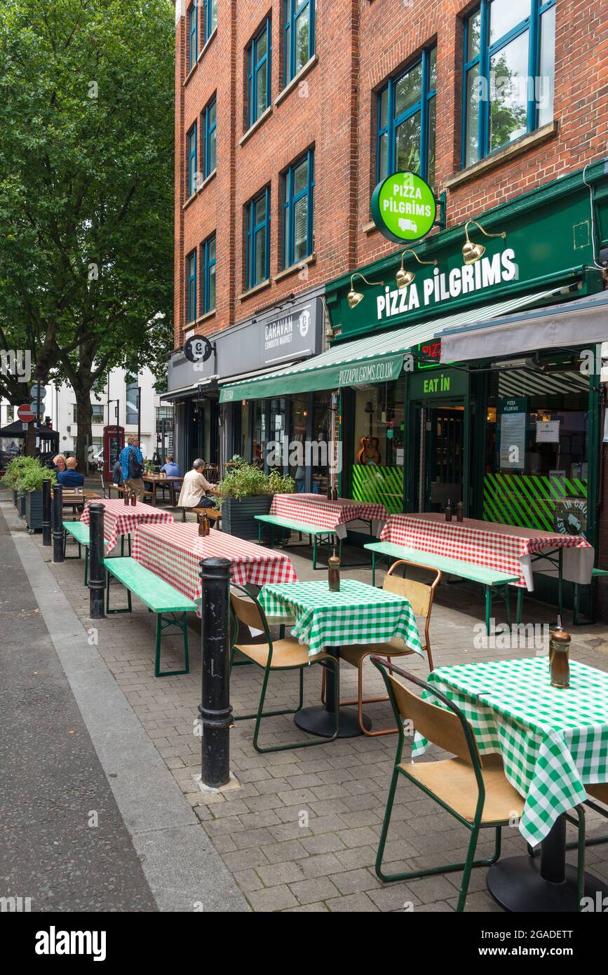 Pavement tables set up outside Pizza Pilgrims and Caravan restaurants ...