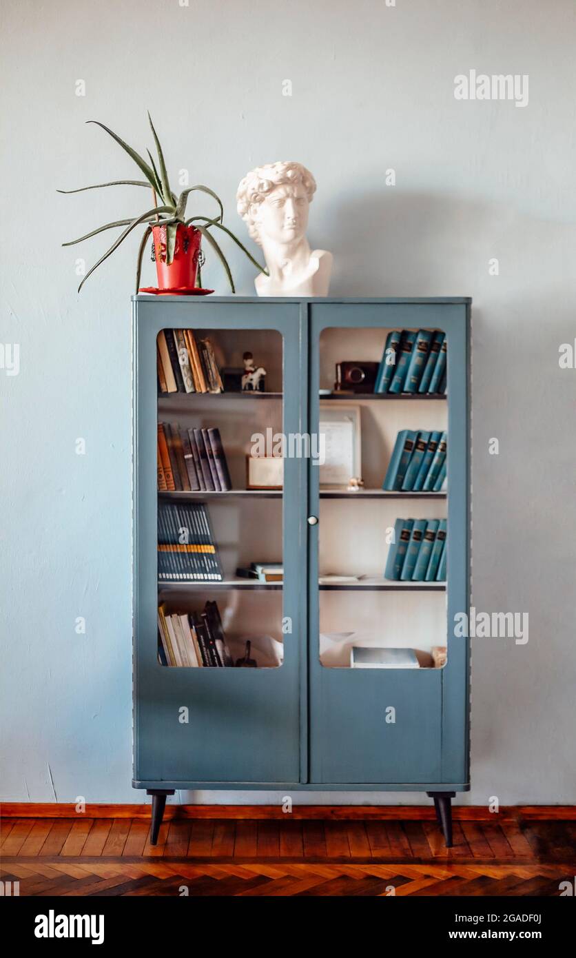 Vintage retro pastel blue bookcase standing on wooden varnished parquet ...