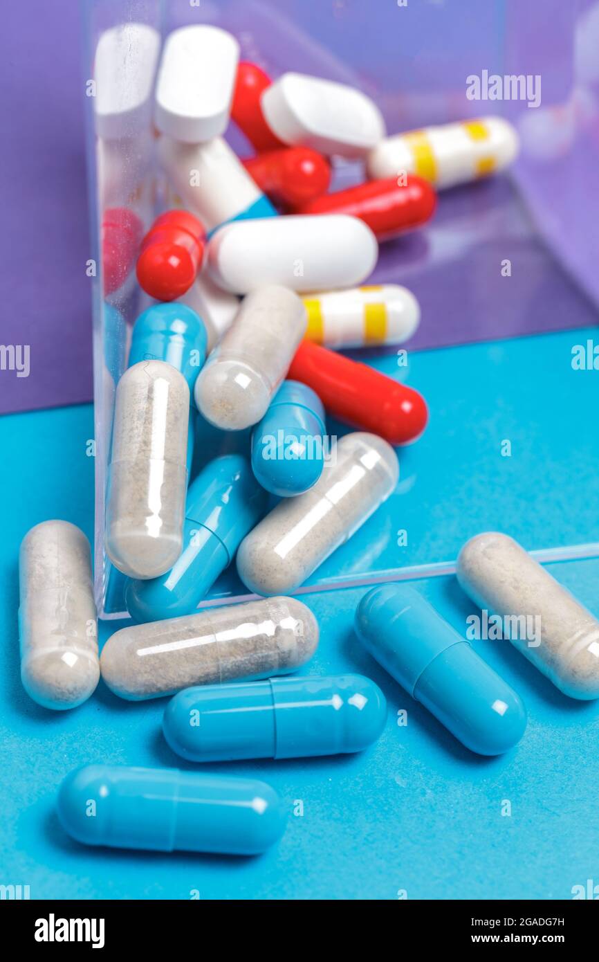 set of multi-colored tablets and capsules on a blue background Stock ...