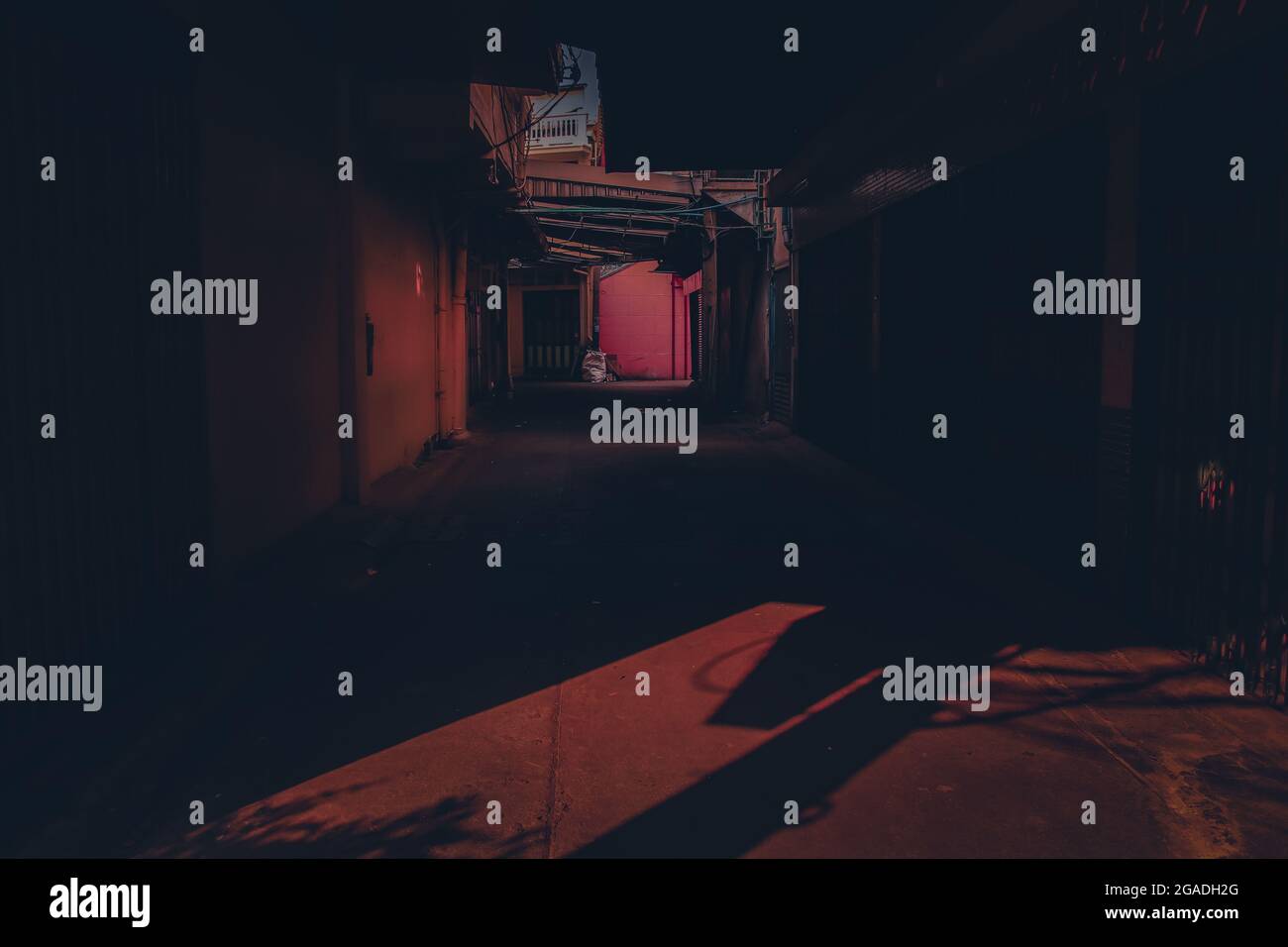 Dark alleyway with red and black shadows Stock Photo - Alamy