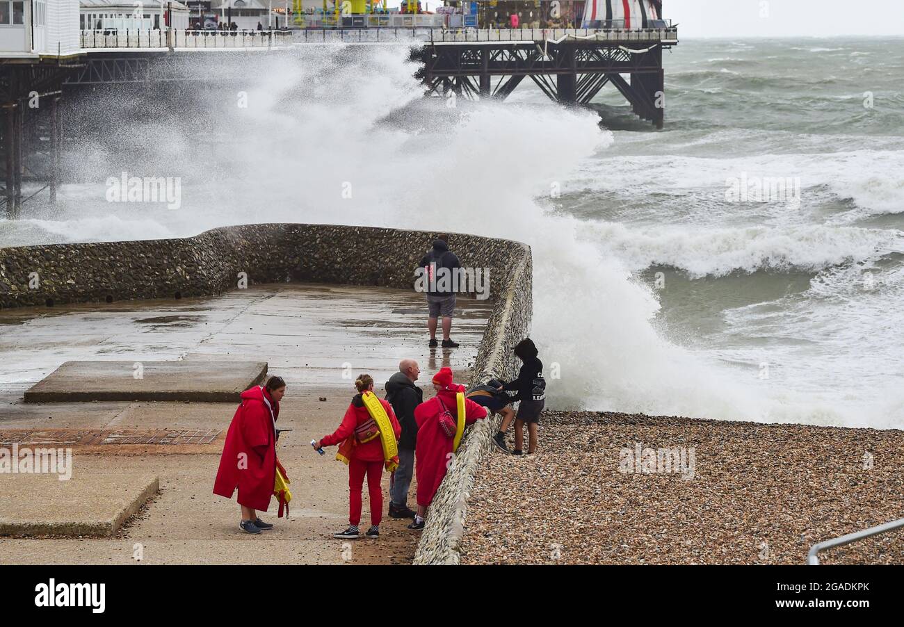Brighton UK 30th July 2021 - Waves crash on to Brighton seafront by the ...